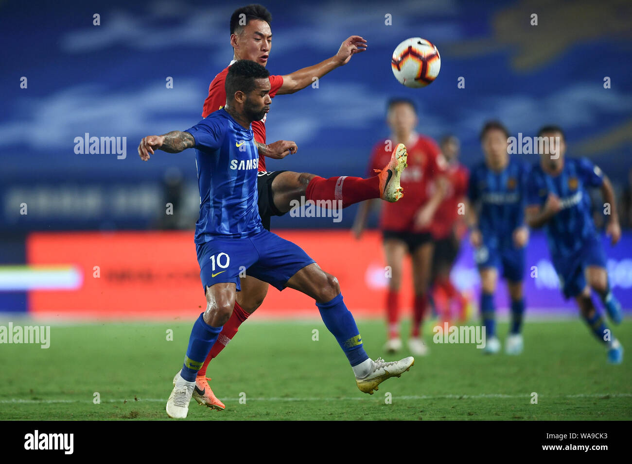 Brazilian football player Alex Teixeira, left, of Jiangsu Suning passes ...