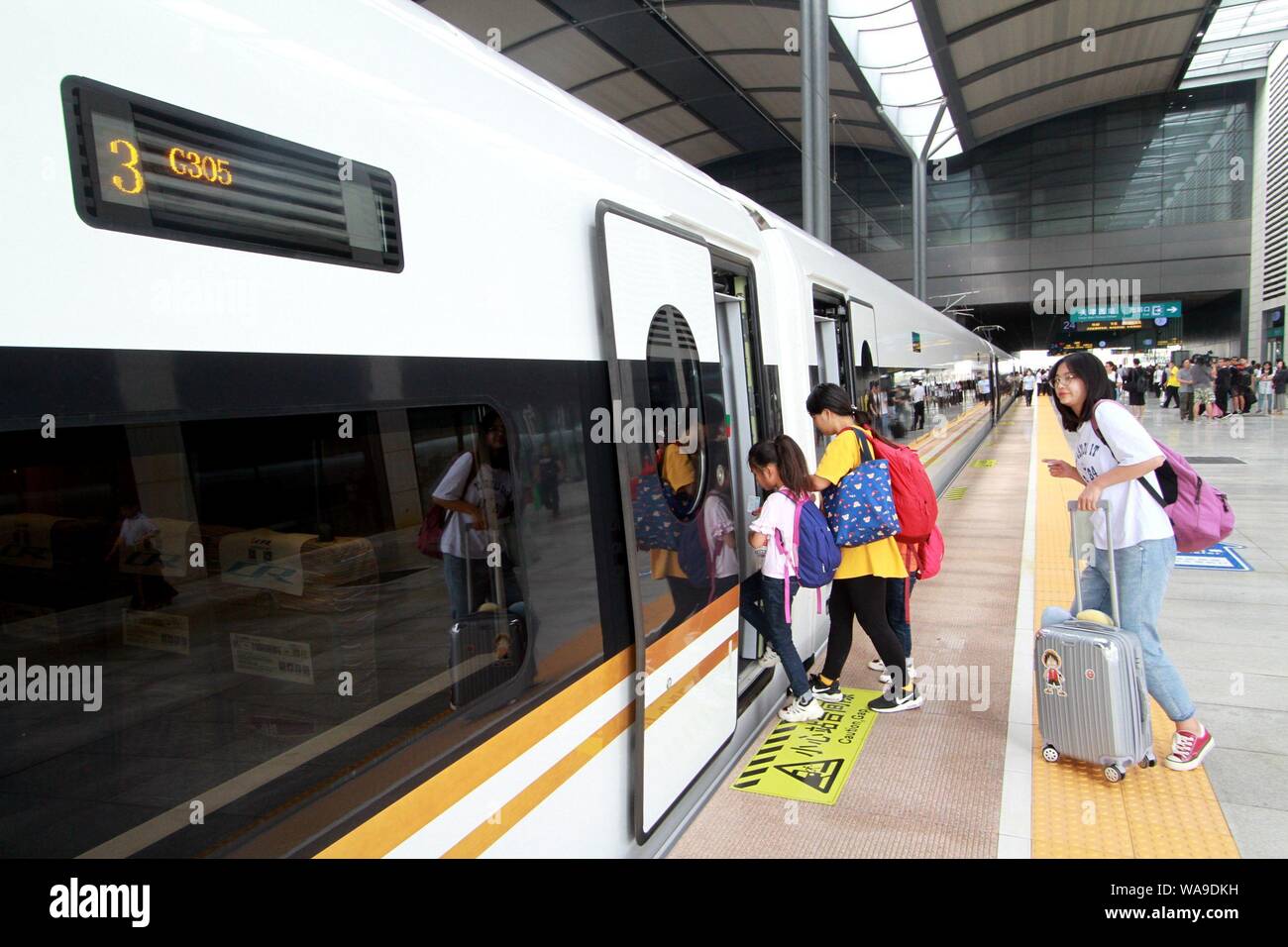 Passengers board the first high-speed railway bullet train linking ...