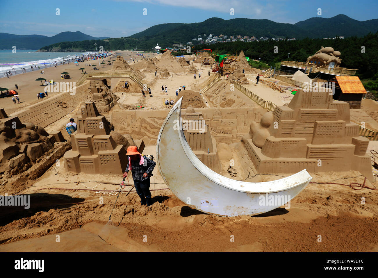 Chinese workers carve sand sculptures featuring shape of cartoon ...