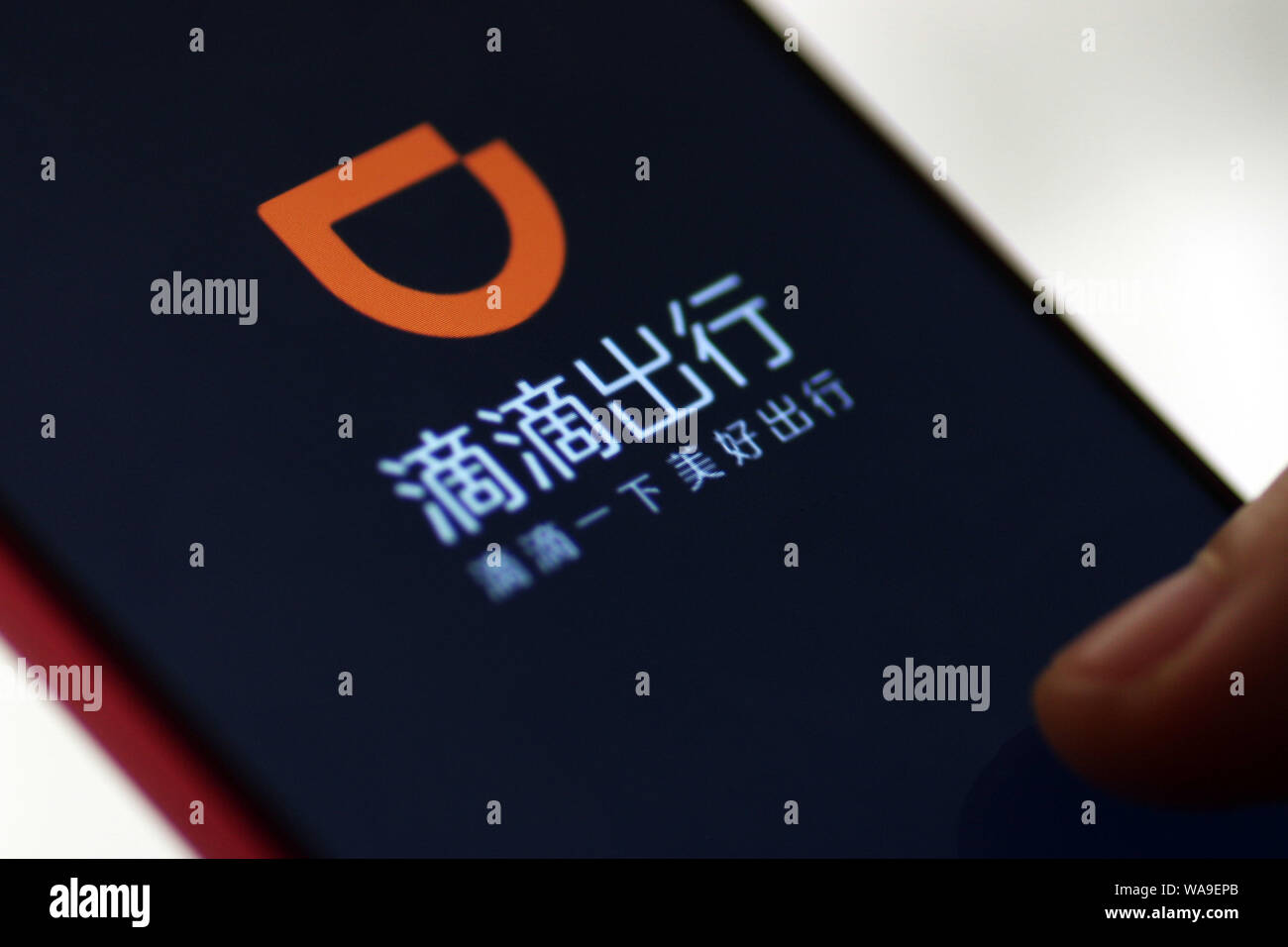 --FILE--A netizen browses the mobile app of taxi-hailing and car ...