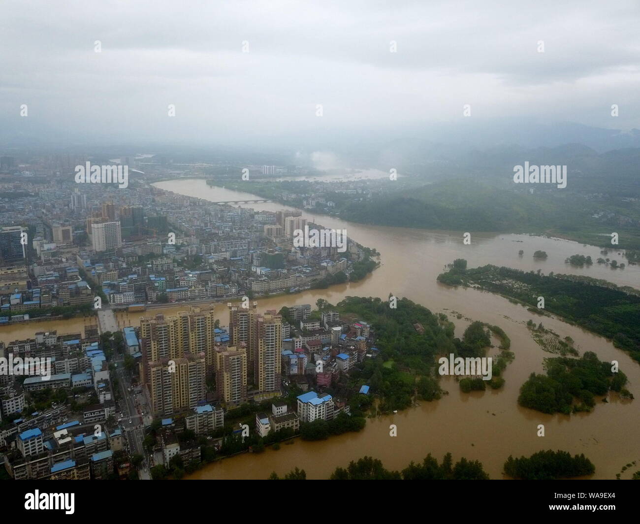 Residential buildings are surrounded by the flooded Xingjiang River ...