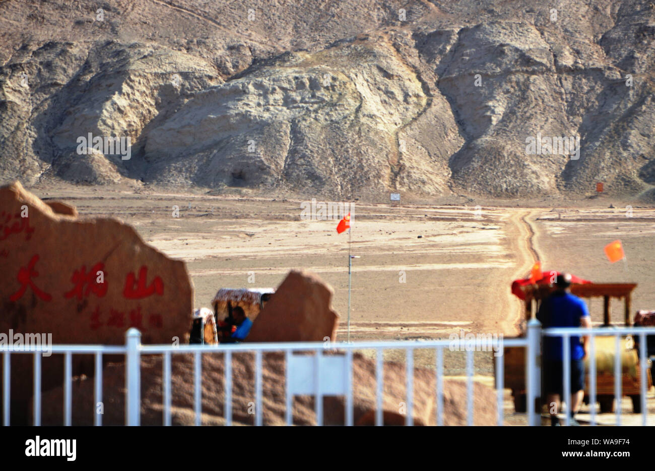 Tourists pose for photos with the landmark sculpture at the foot of the ...