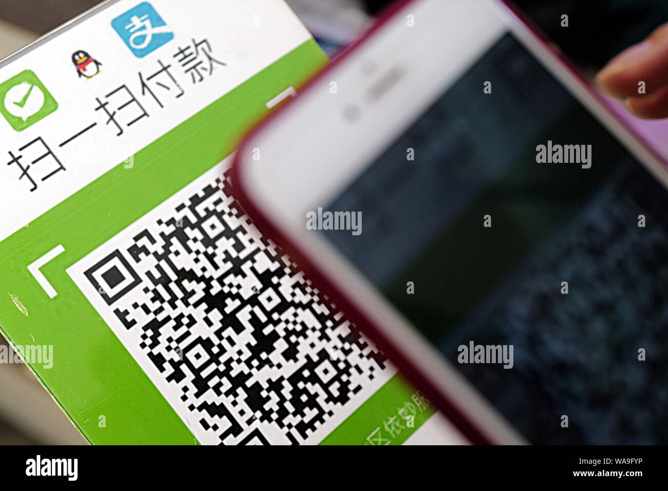 --FILE--A Chinese mobile phone user scans a QR code via mobile payment ...