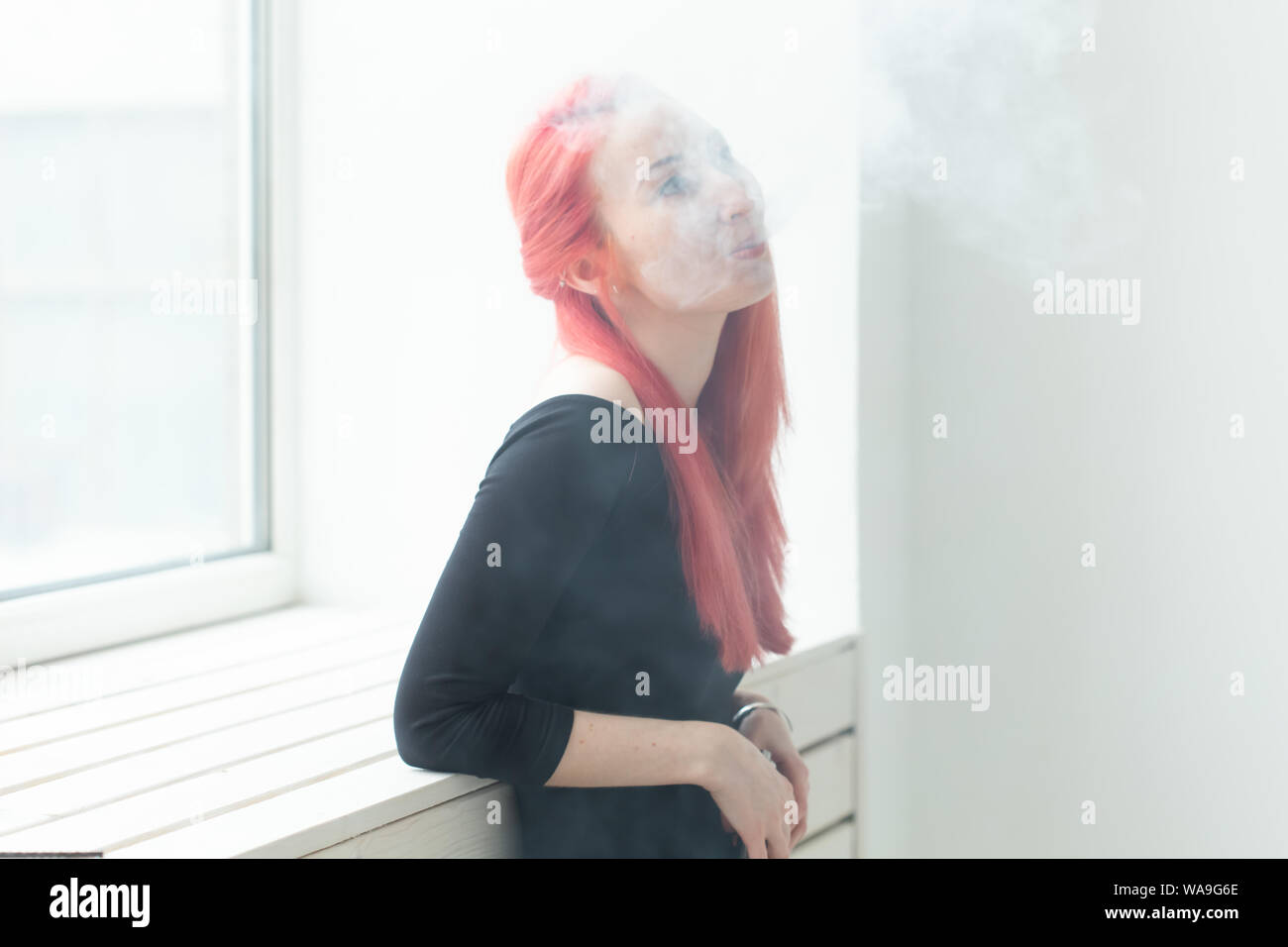 Vape, addiction and people concept - woman with red hair is smoking ...