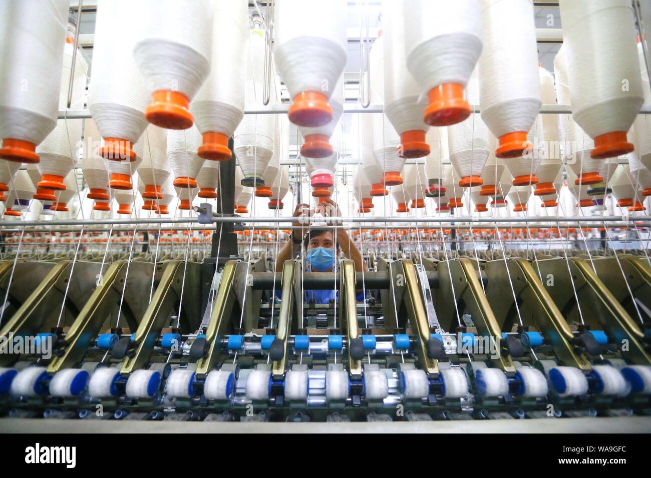 --FILE--A female Chinese worker handles production of yarn at a textile ...