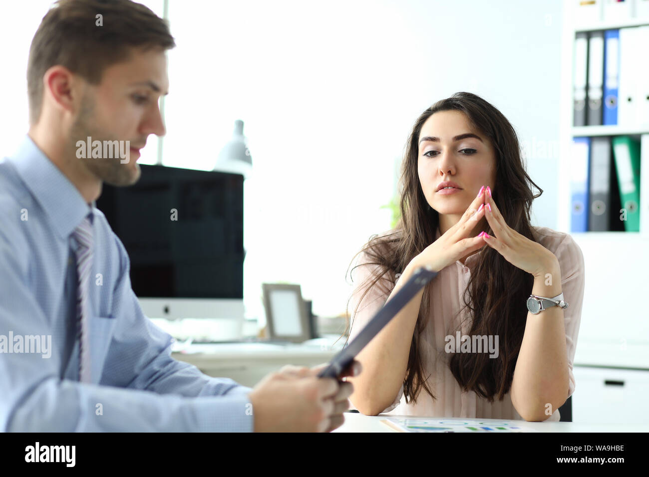 Businesslady looking at partner with interest Stock Photo - Alamy