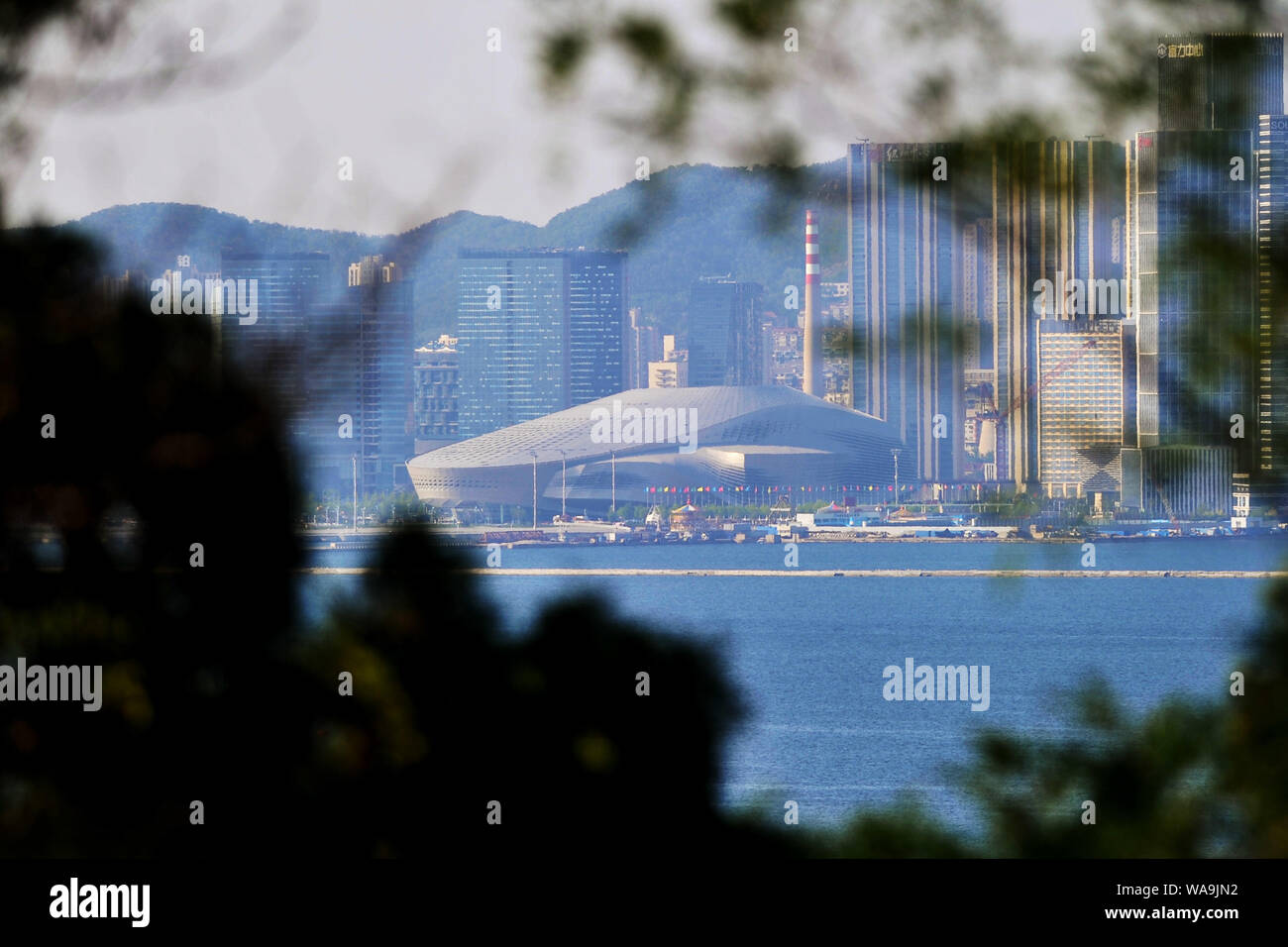 A passenger boat passes the Dalian International Conference Center for ...