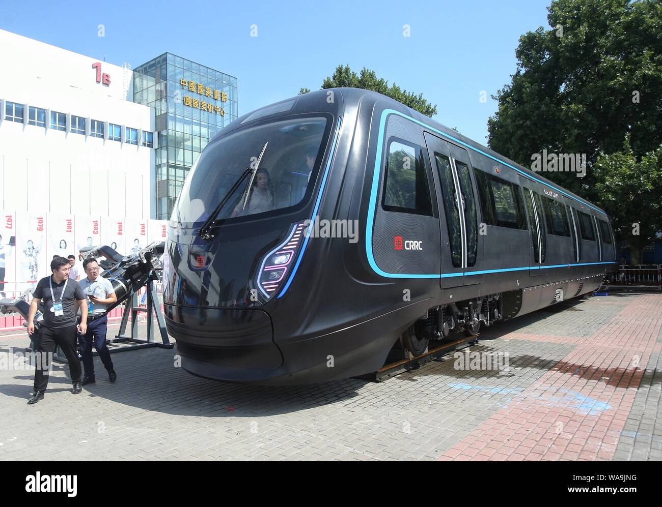 Visitors walk past a new generation carbon fiber metro car Visitors walk past a new generation carbon fiber metro car