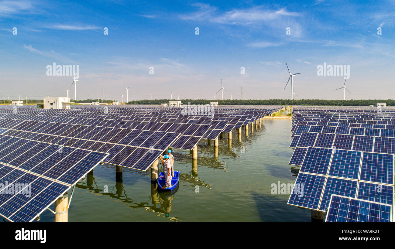 Chinese workers install solar panels at a photovoltaic power station in ...
