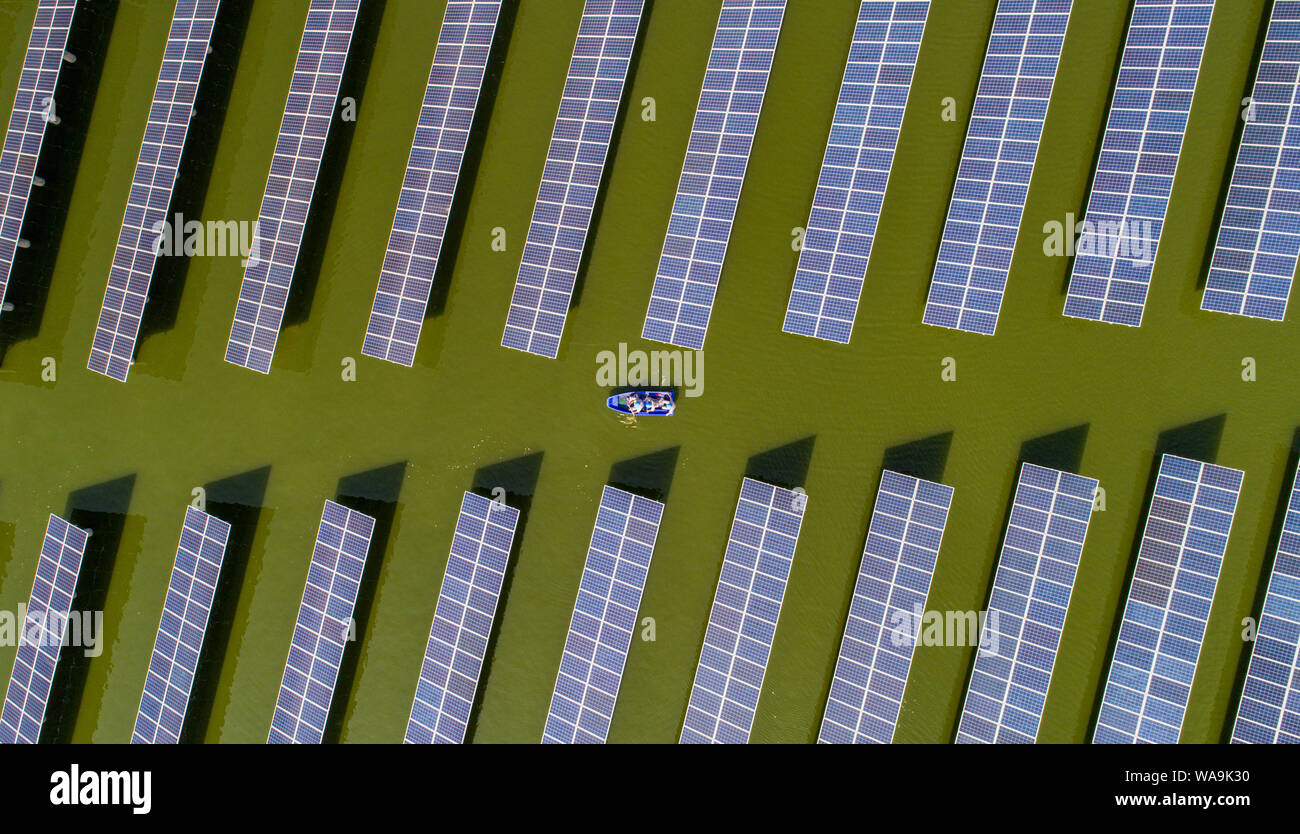 Chinese workers install solar panels at a photovoltaic power station in ...