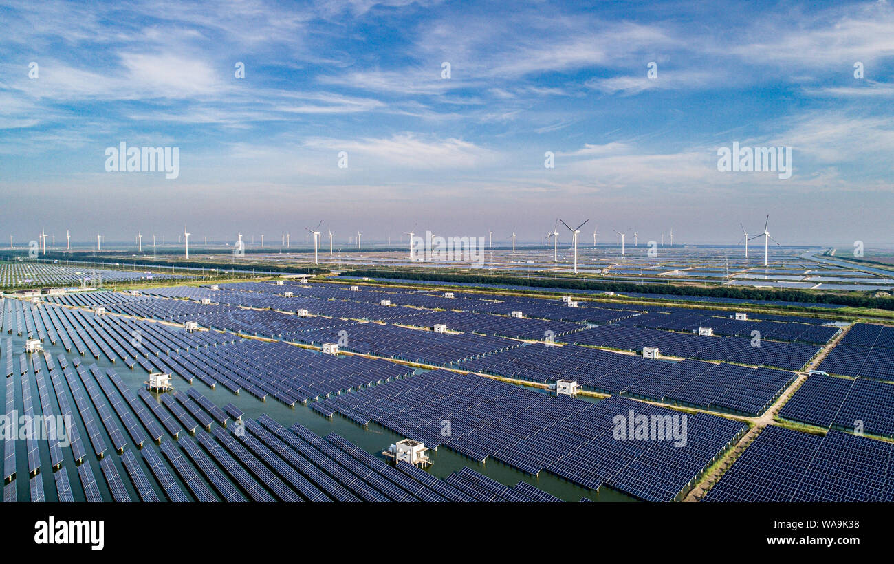 Chinese workers install solar panels at a photovoltaic power station in ...