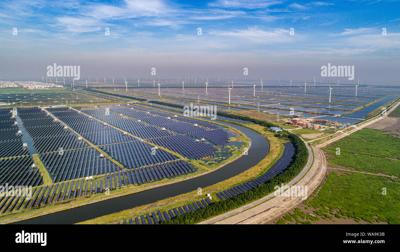 Chinese workers install solar panels at a photovoltaic power station in ...