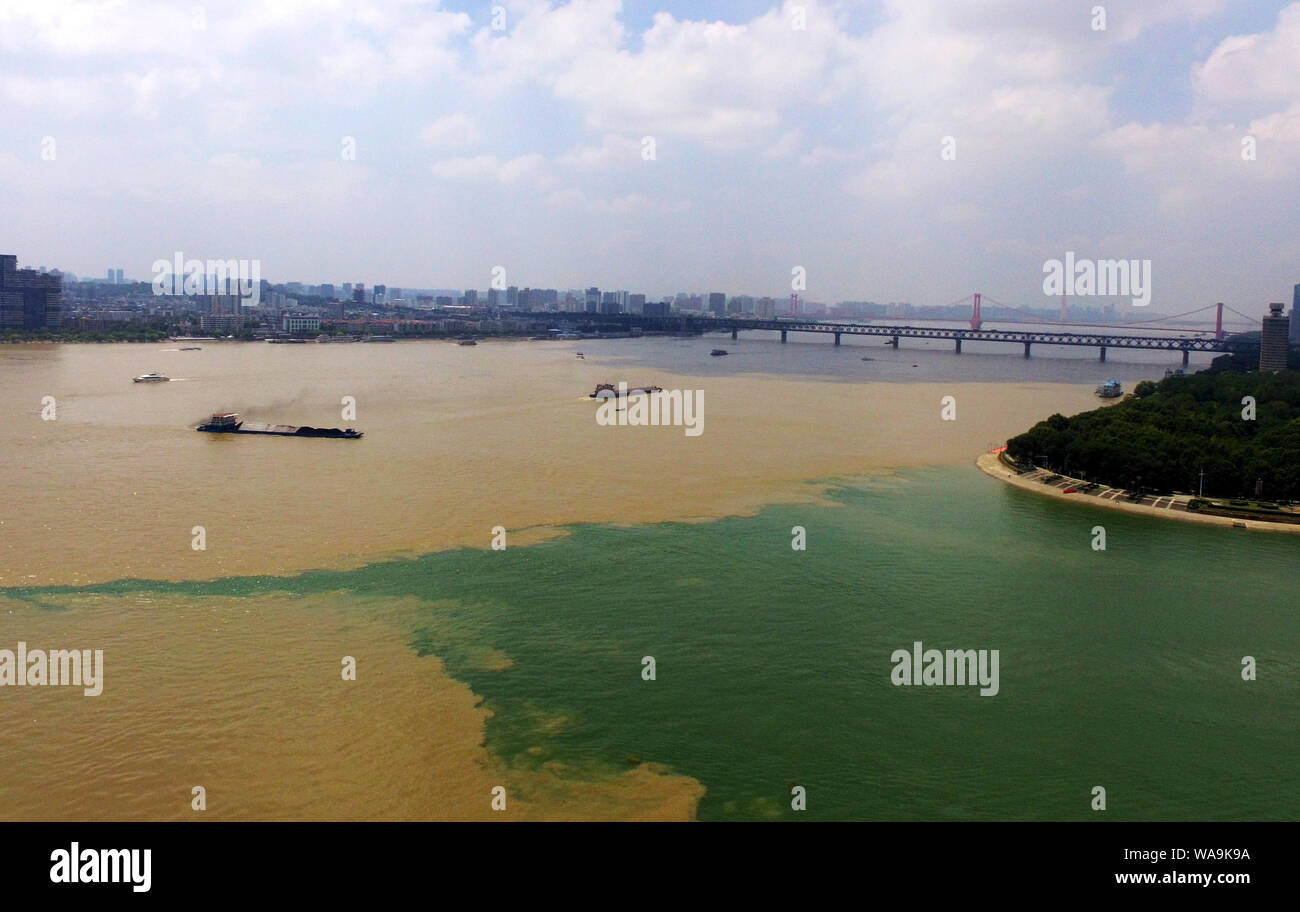 Boats shuttle back and forth on the confluence formed by sandy Yangtze ...