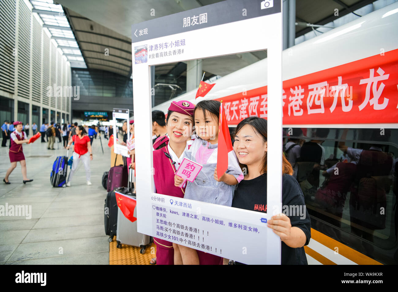 Chinese train attendants pose with passengers in front of the first ...