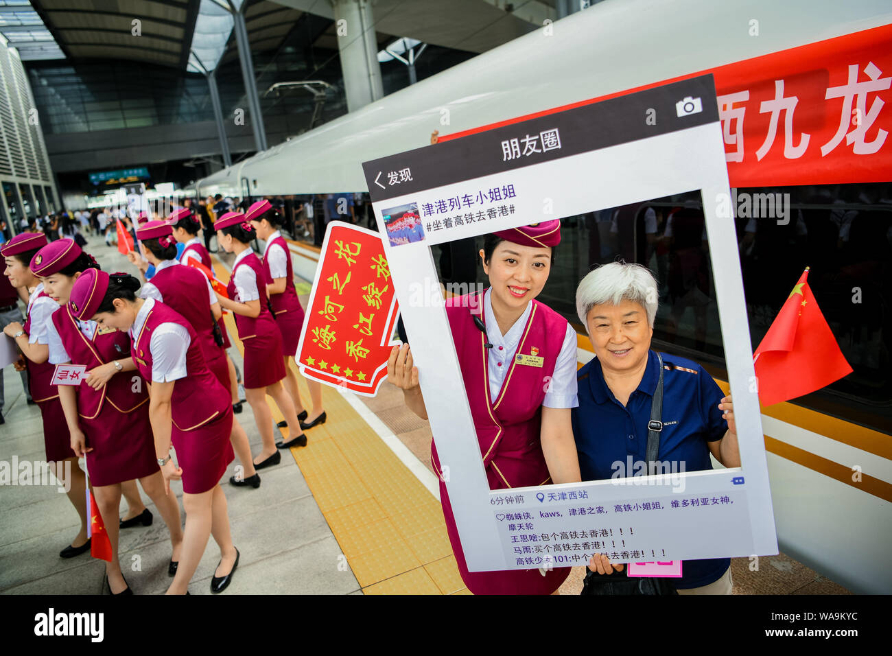 Chinese train attendants pose with passengers in front of the first ...