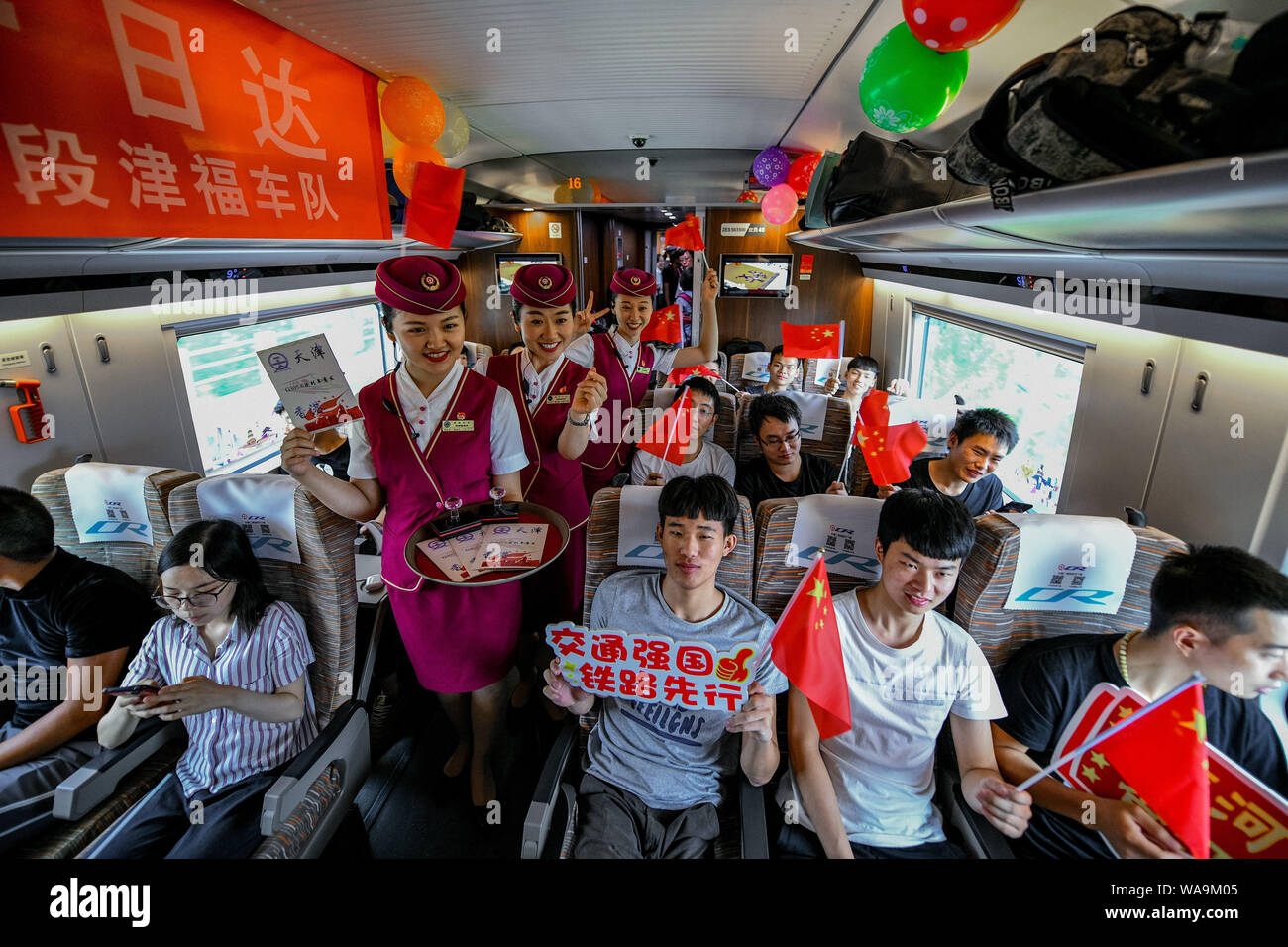 Chinese train attendants pose with passengers in the first high-speed ...