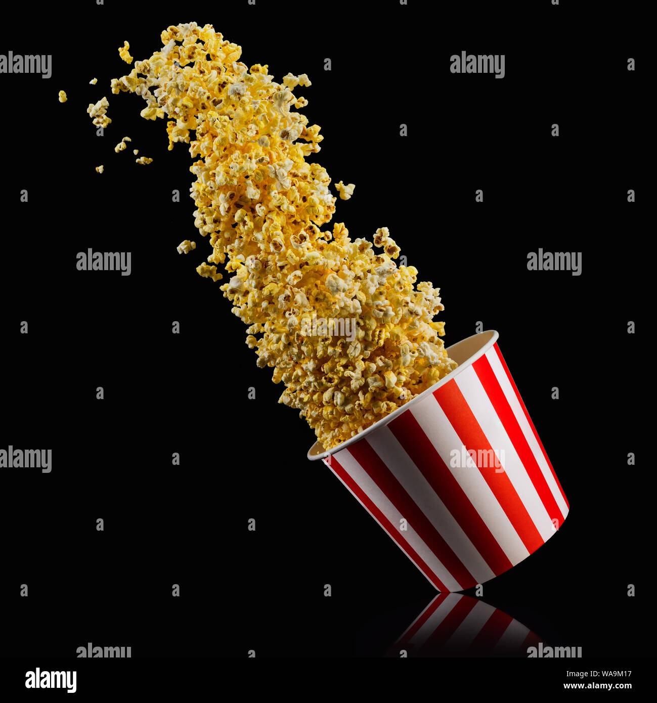 Flying popcorn from striped bucket isolated on black background Stock ...