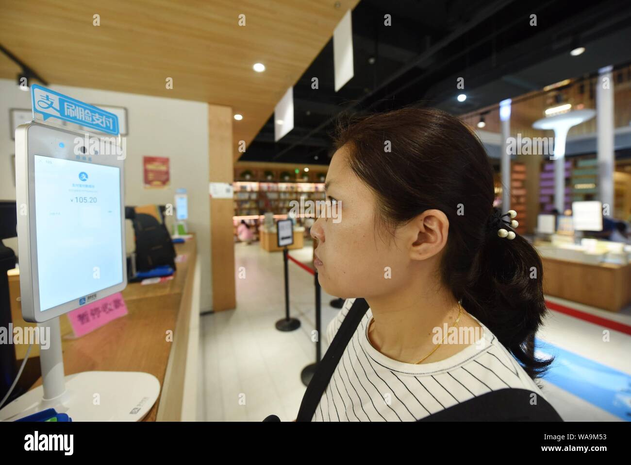 A female customer has her face scanned by a face recognition system ...