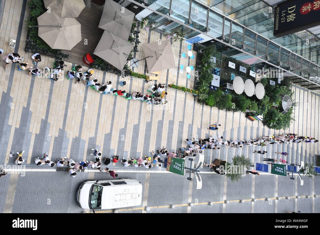 Chinese fans wait in a long queue in front of a milk tea store operated ...