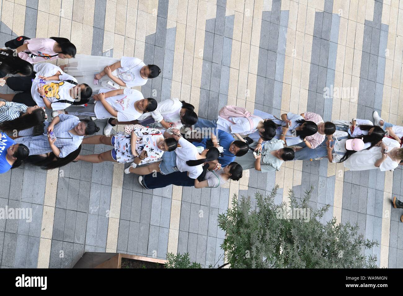 Chinese fans wait in a long queue in front of a milk tea store operated ...