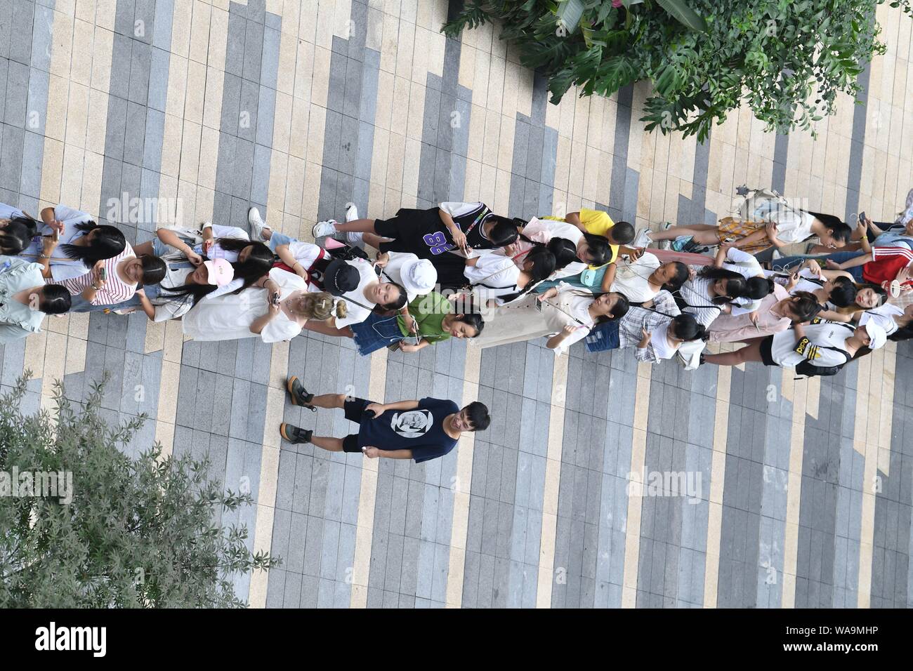 Chinese fans wait in a long queue in front of a milk tea store operated ...