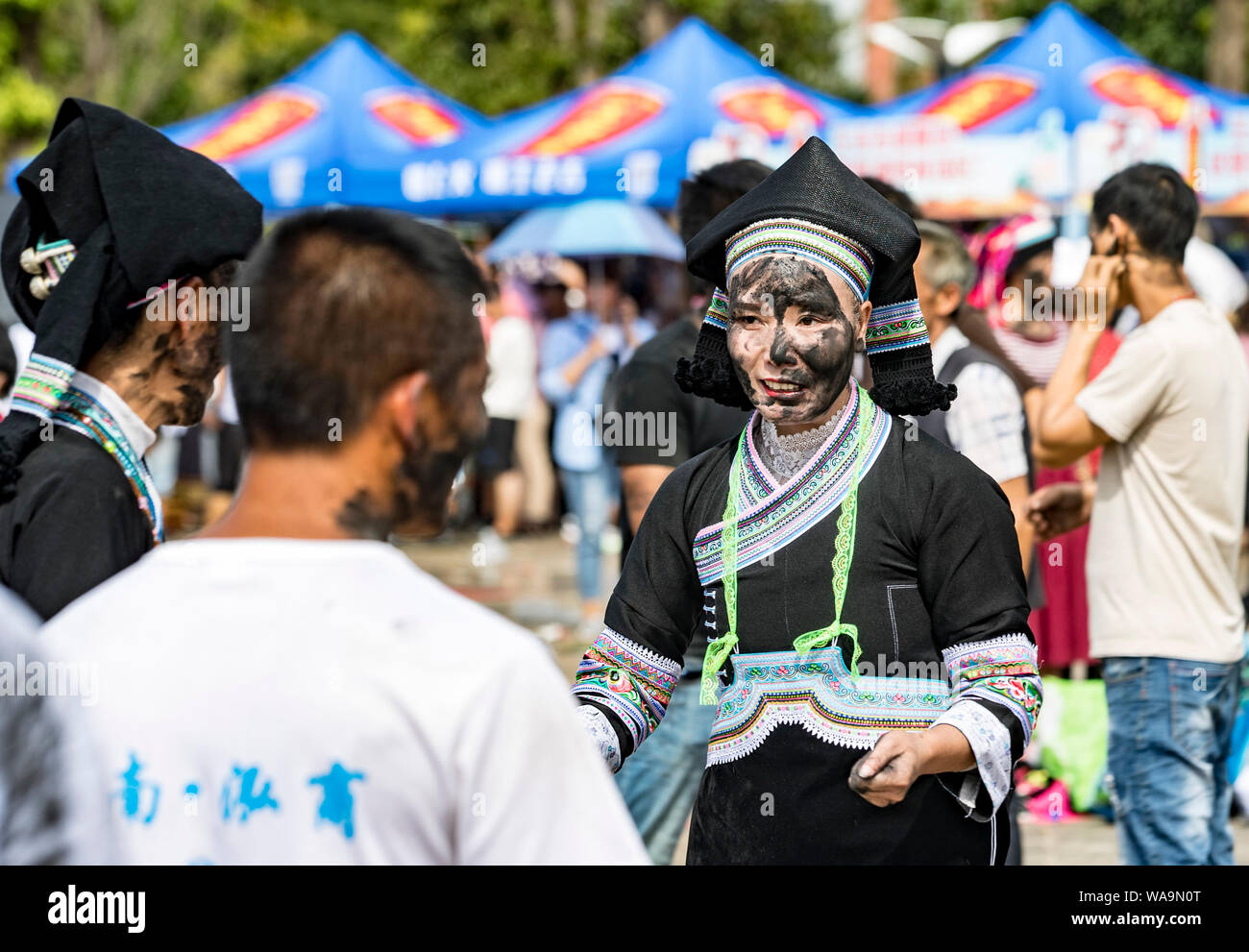 Chinese people of the Yi ethnic group daub their faces black to ...