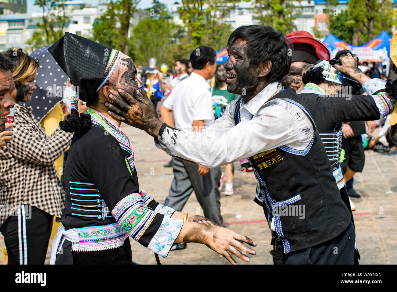 Chinese people of the Yi ethnic group daub their faces black to ...