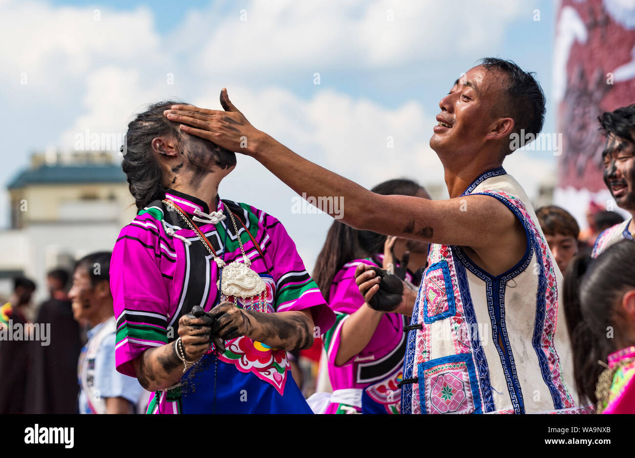 Chinese people of the Yi ethnic group daub their faces black to ...