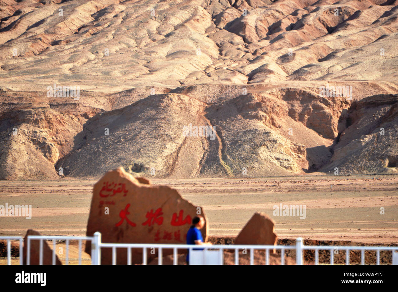Tourists pose for photos with the landmark sculpture at the foot of the ...
