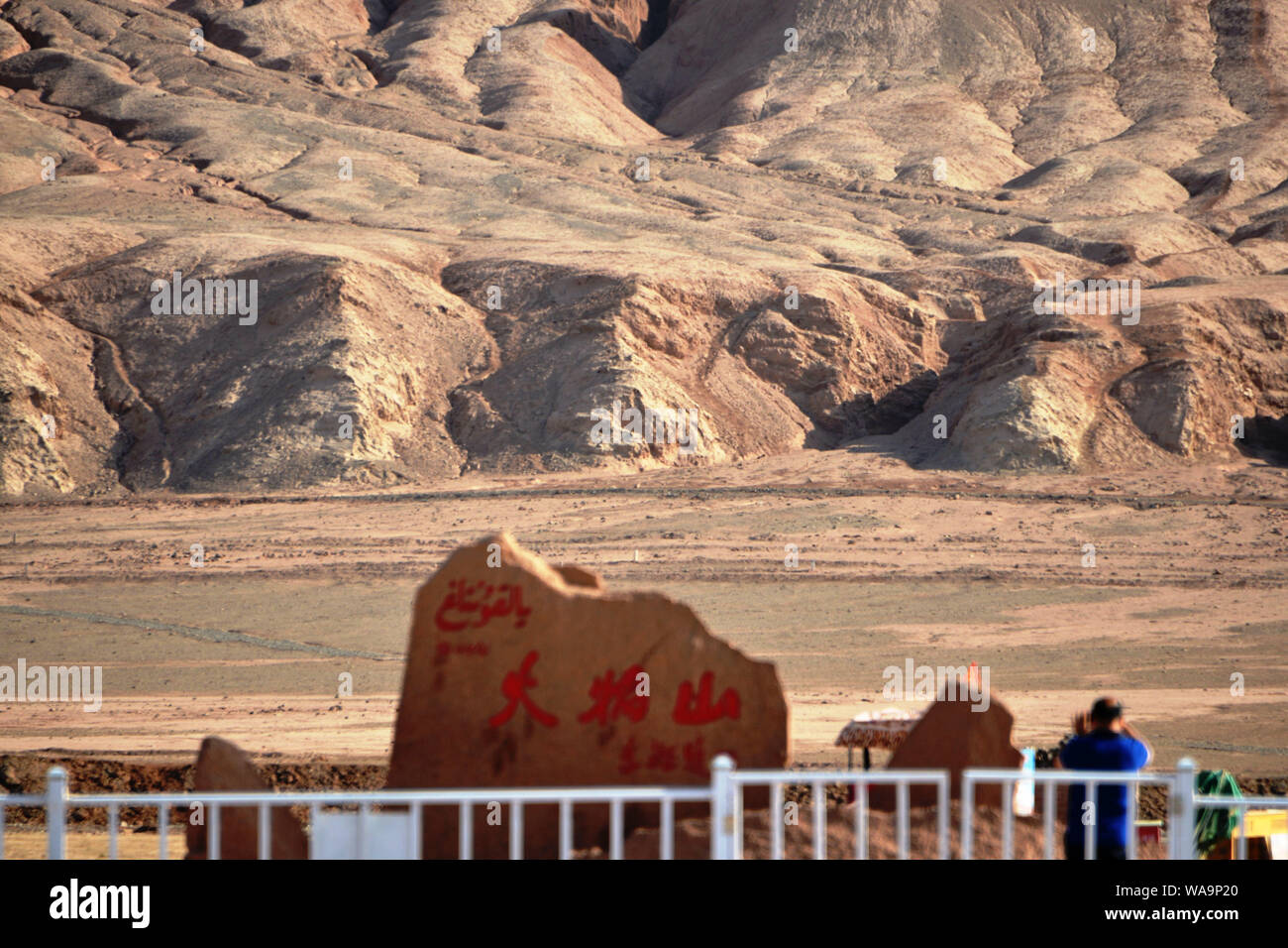 Tourists pose for photos with the landmark sculpture at the foot of the ...