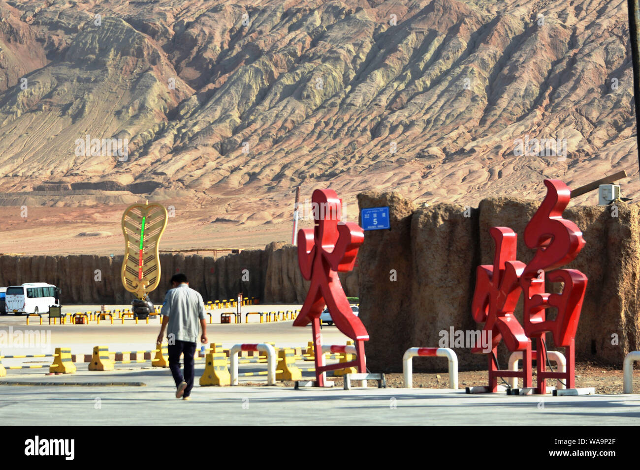 Tourists pose for photos with the landmark sculpture at the foot of the ...