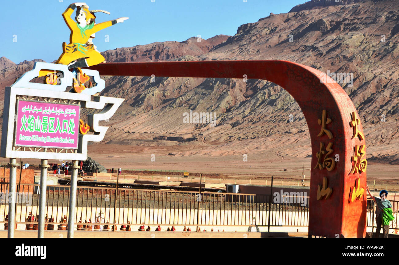 Tourists pose for photos with the landmark sculpture at the foot of the ...
