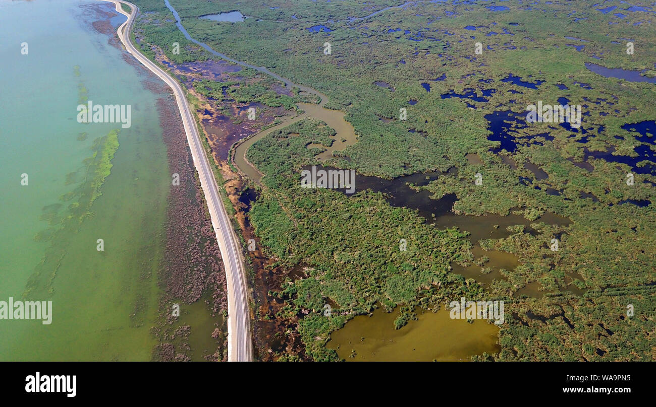 Aerial view of a highway around the Bosten Lake, one of the largest ...