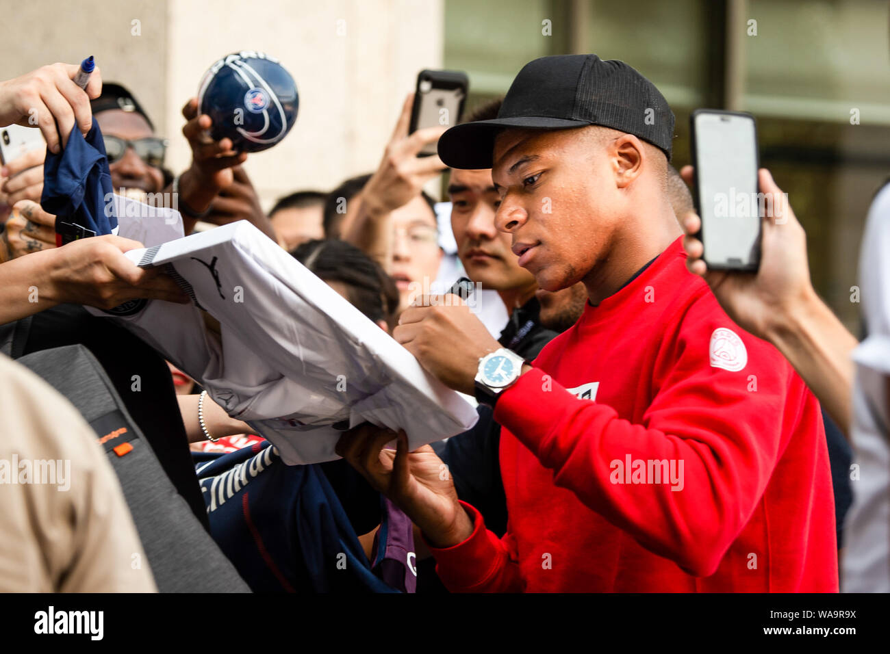 Kylian Mbappe of Paris Saint-Germain F.C. signs autographs for fans ...