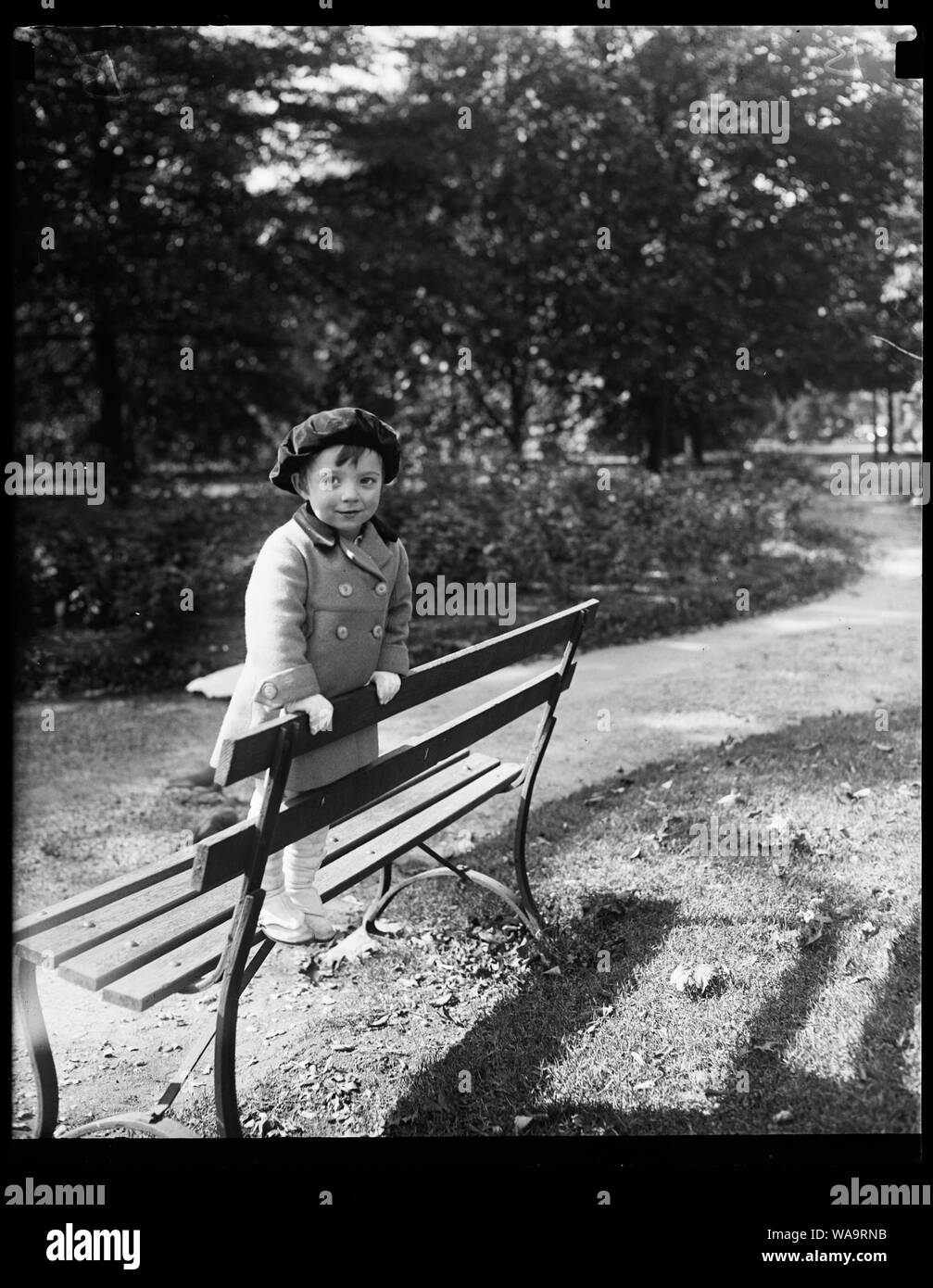 Child on park bench Stock Photo - Alamy