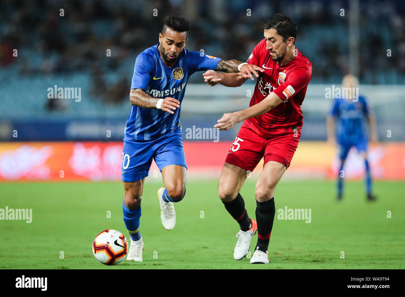 Brazilian football player Alex Teixeira, left, of Jiangsu Suning passes ...