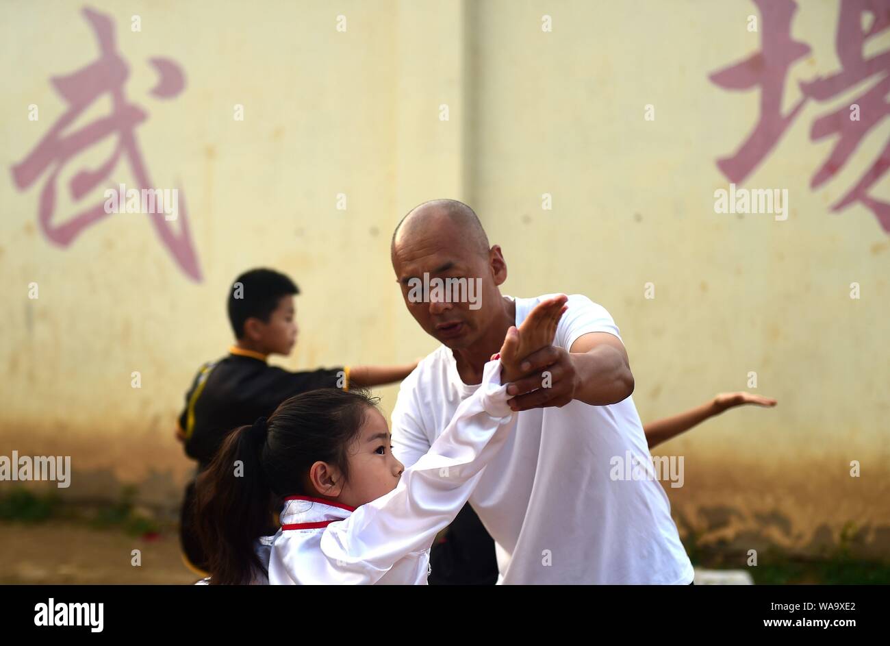 A Chinese child practices Chinese martial arts or kungfu directed by ...