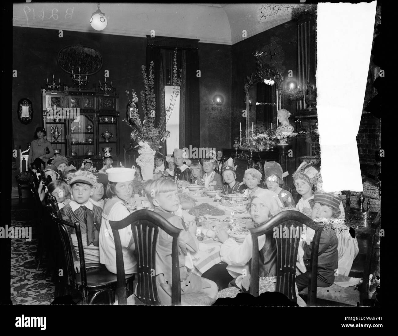 Children wearing costumes seated at table Stock Photo - Alamy