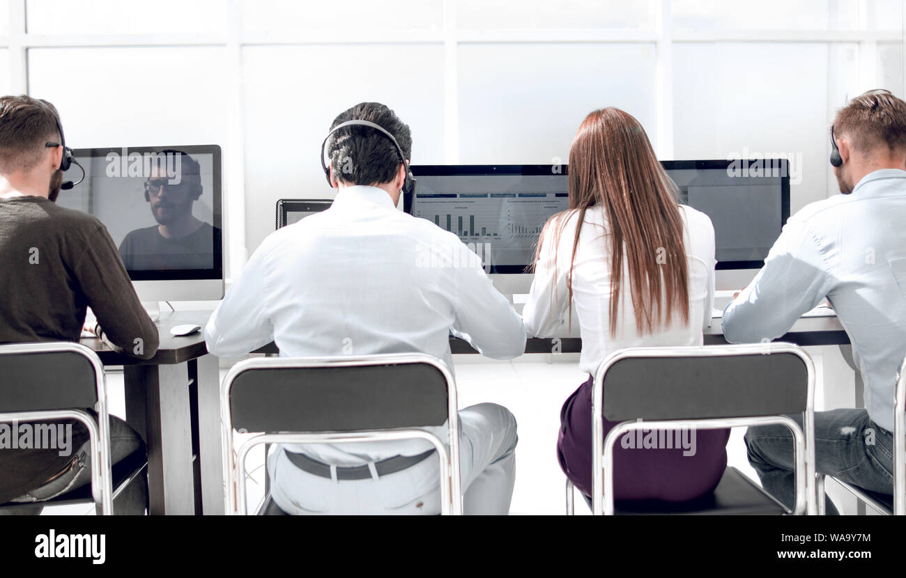 rear view.a group of people in the headset works in a modern office ...