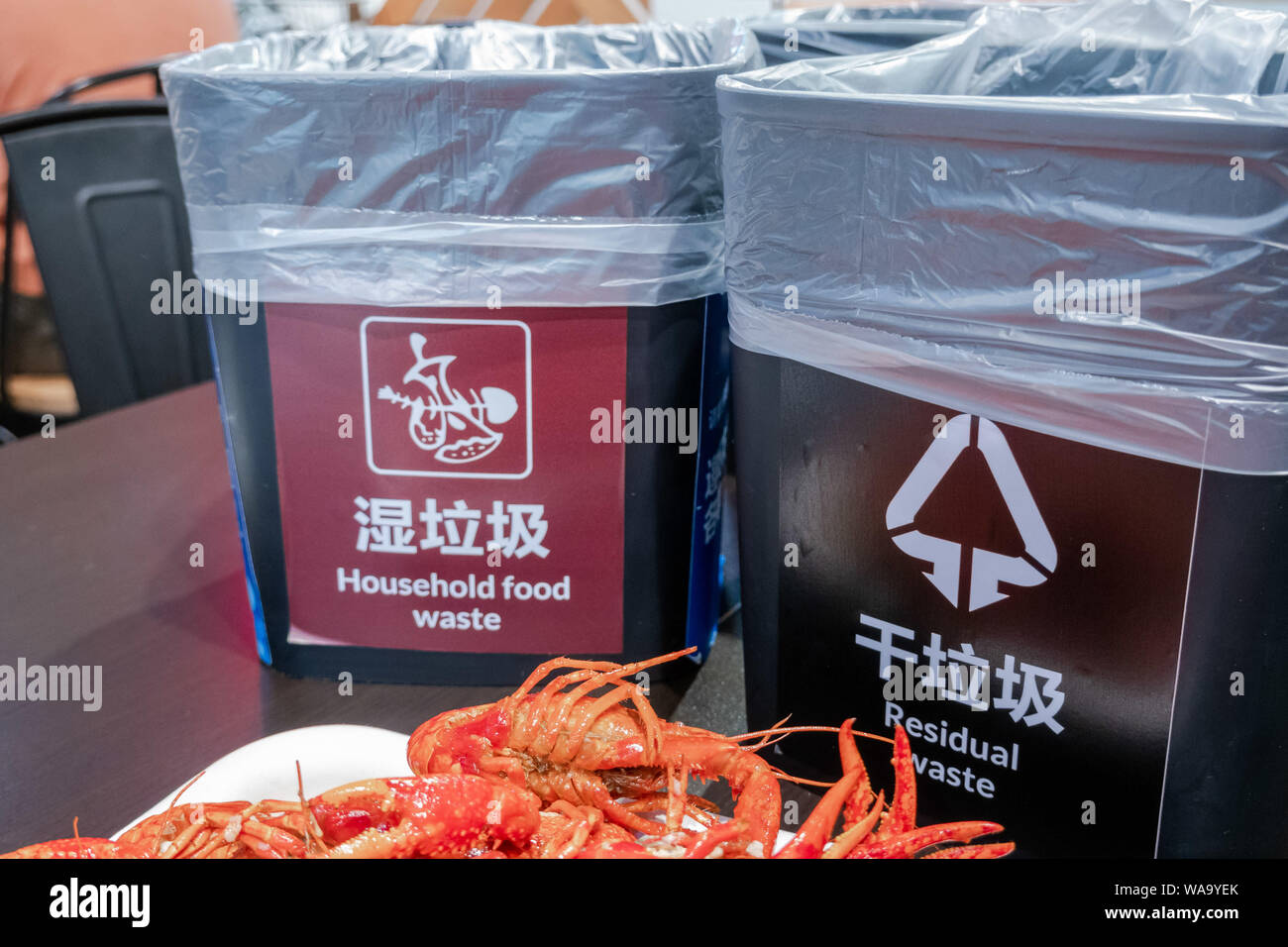 A customer puts waste of crayfish into a bin at a store of O2O fresh ...