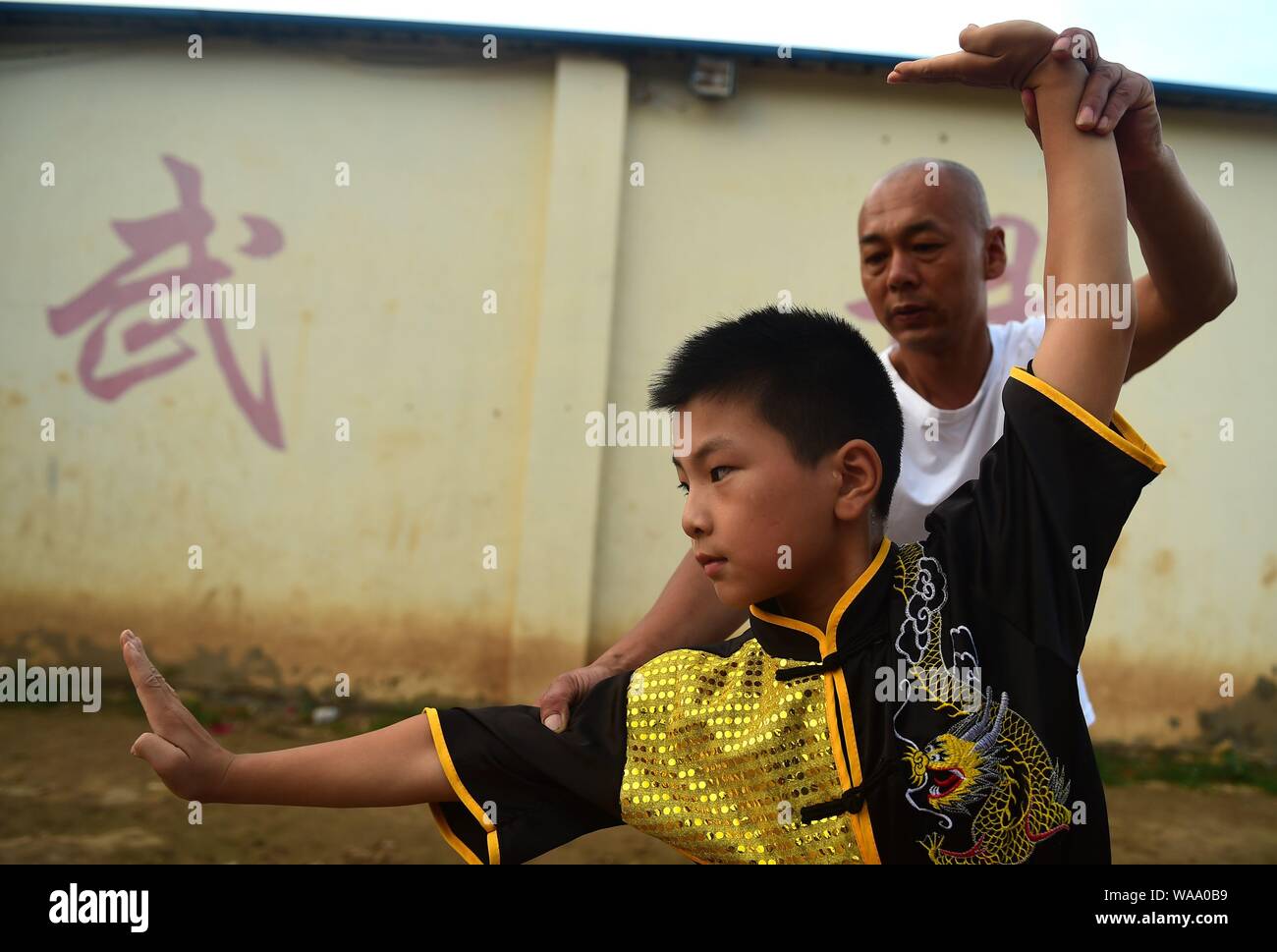 A Chinese child practices Chinese martial arts or kungfu directed by ...