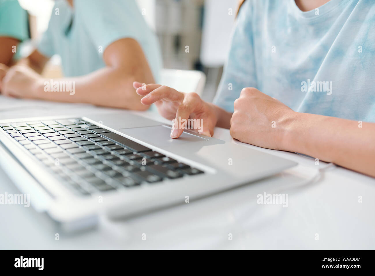 Young person pressing button on laptop pad while sitting by desk Stock ...