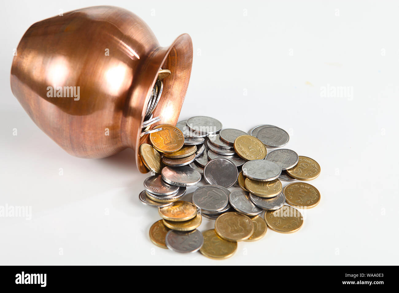 Indian coins spilling out of a brass pot Stock Photo - Alamy