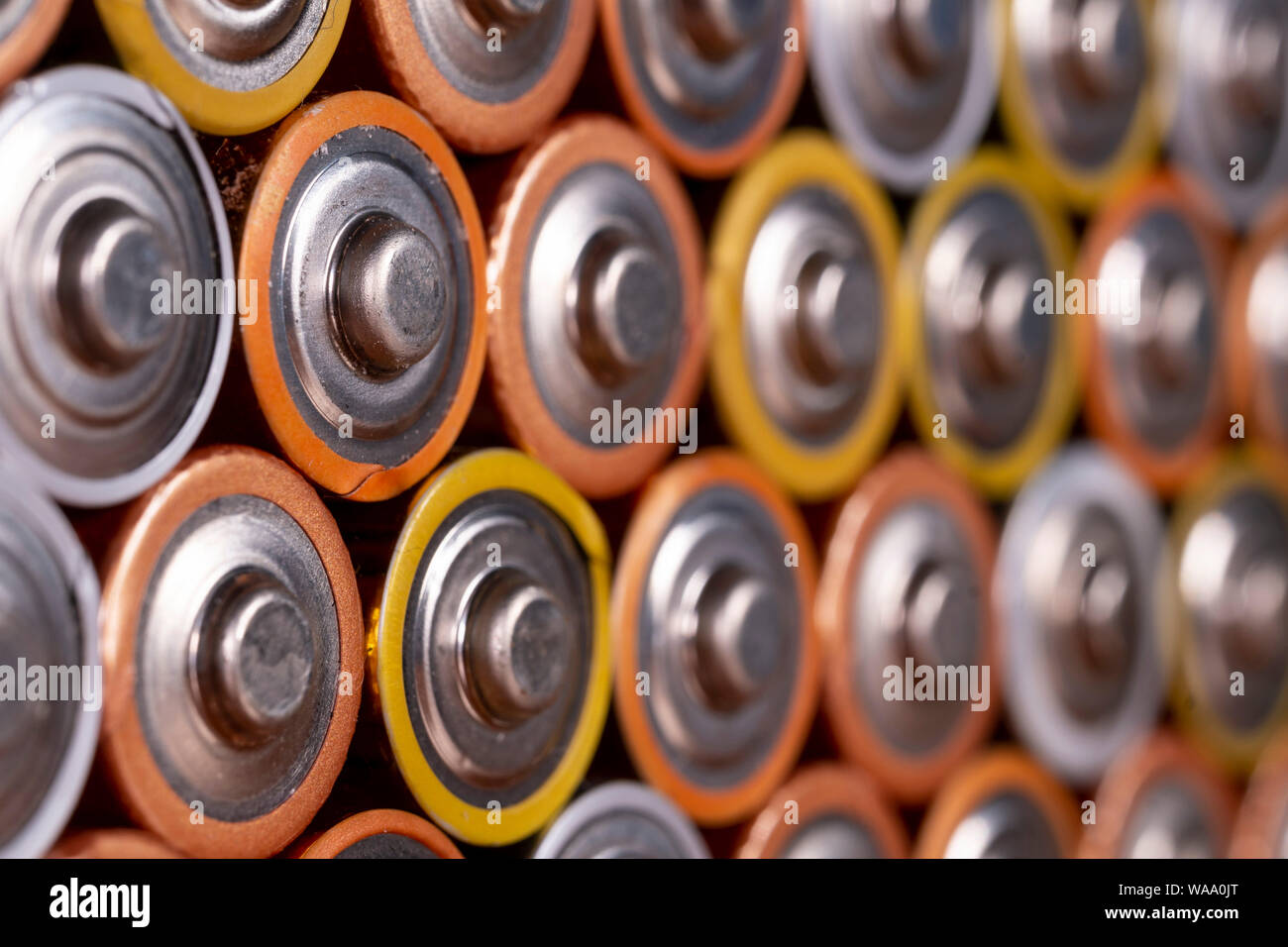 Multiple used AA alkaline batteries are seen arranged in a pile ...