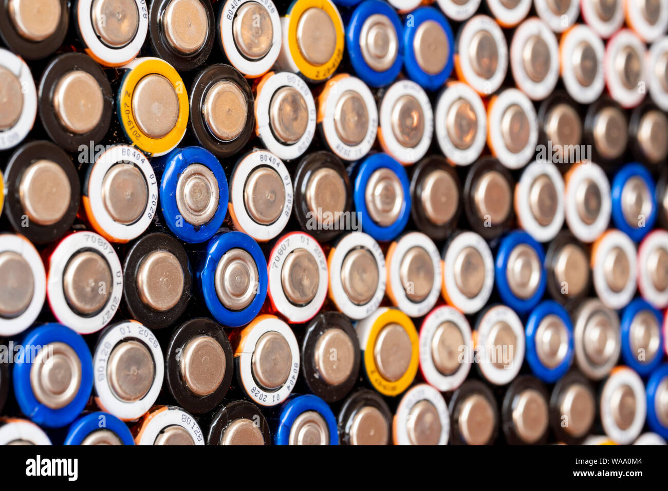 Multiple used AA alkaline batteries are seen arranged in a pile ...
