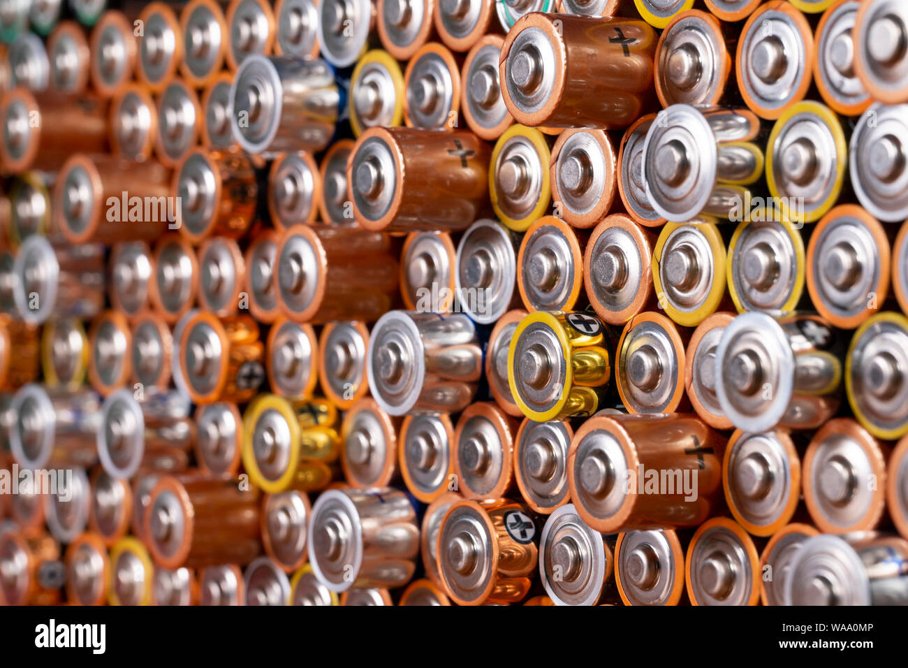 Multiple used AA alkaline batteries are seen arranged in a pile ...