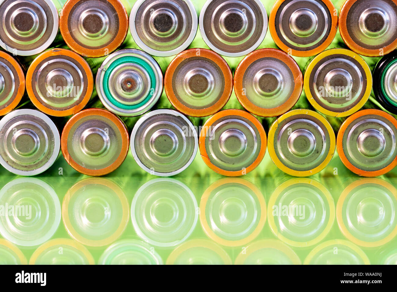 Multiple used AA alkaline batteries are seen arranged in a pile on a ...