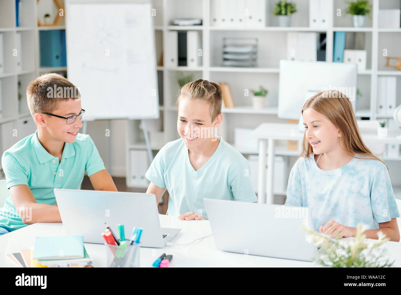 Schoolkids sitting table using computer hi-res stock photography and ...