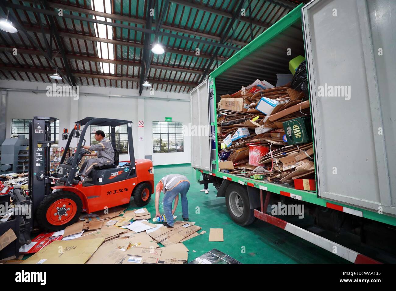 A Chinese worker sorts out recycling waste at a distribution center of ...