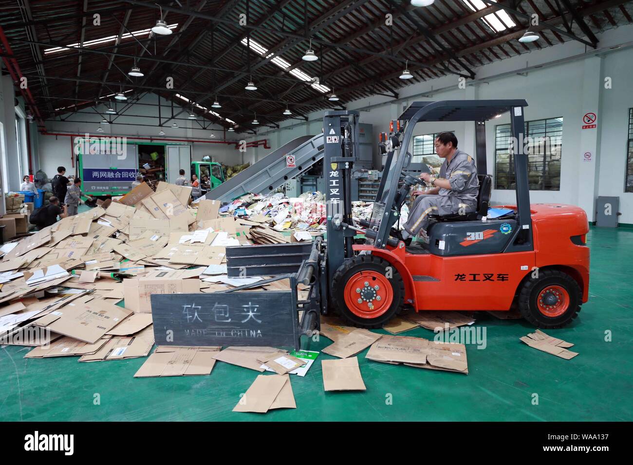 A Chinese worker sorts out recycling waste at a distribution center of ...